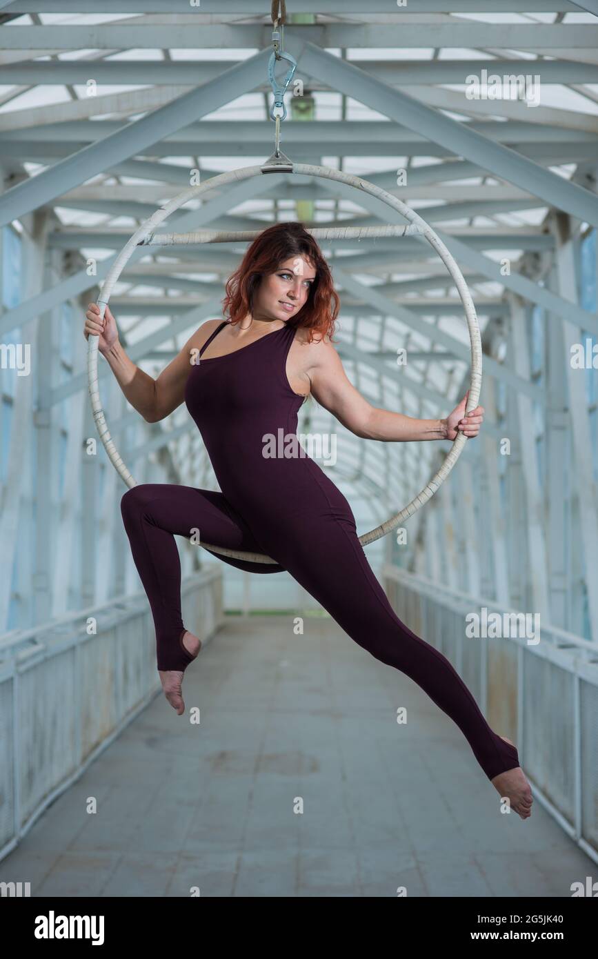 The red-haired aerial gymnast in a sports combo performs at the air ...