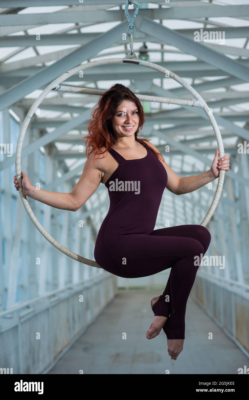 The red-haired aerial gymnast in a sports combo performs at the air ...