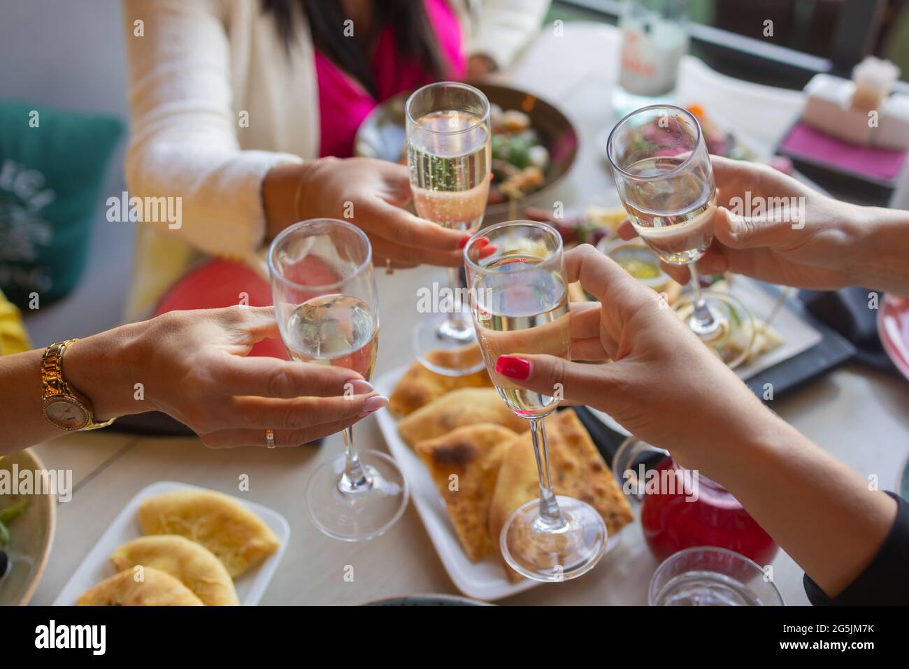 Clinking glasses with alcohol and toasting, party Stock Photo - Alamy