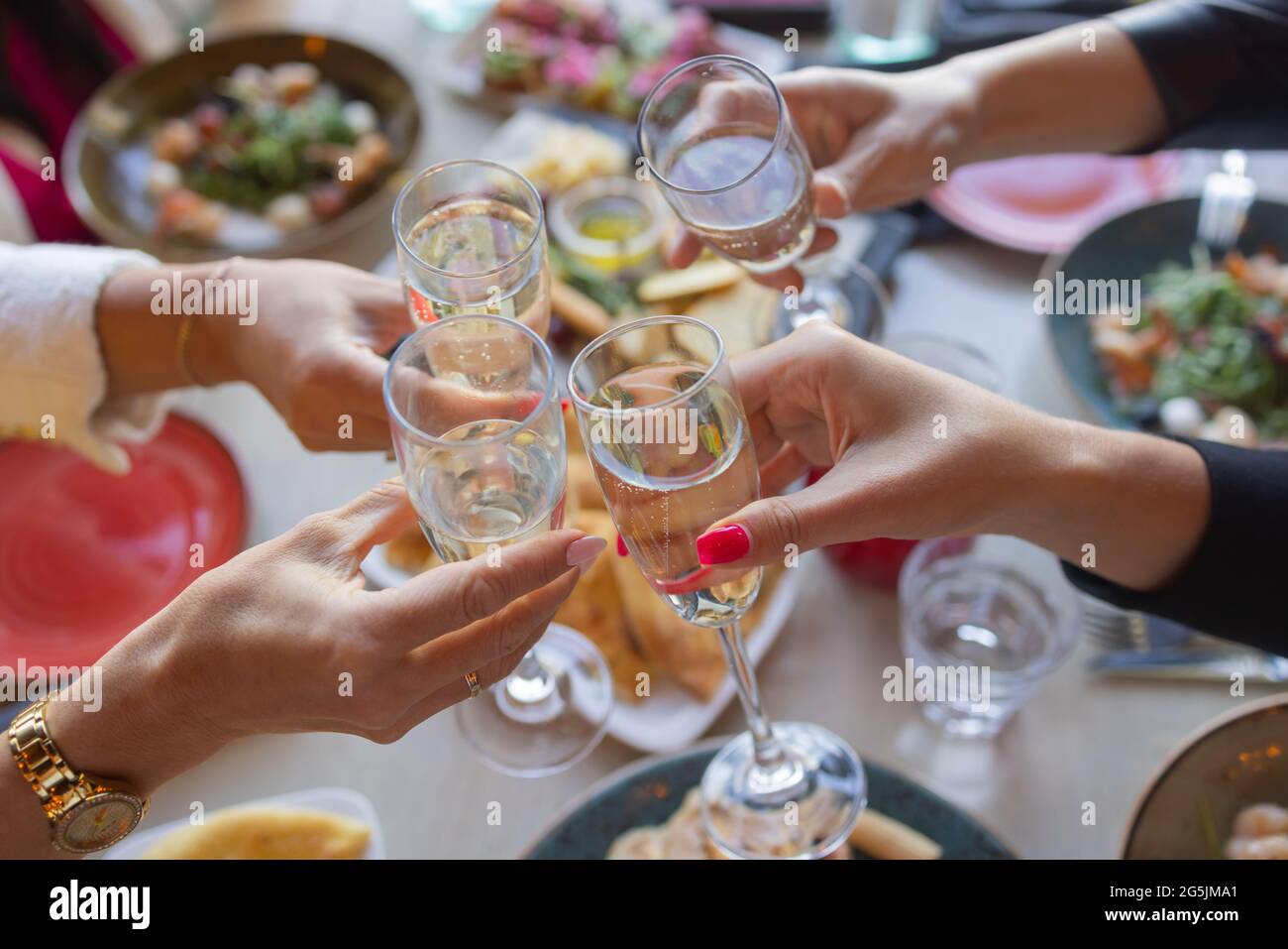 Clinking glasses with alcohol and toasting, party Stock Photo - Alamy