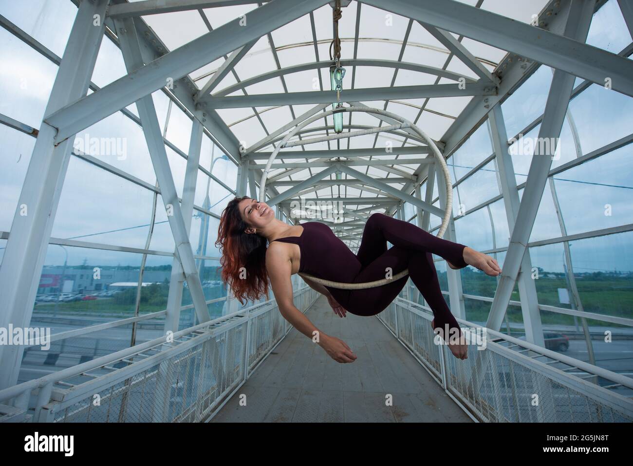 The red-haired aerial gymnast in a sports combo performs at the air ...