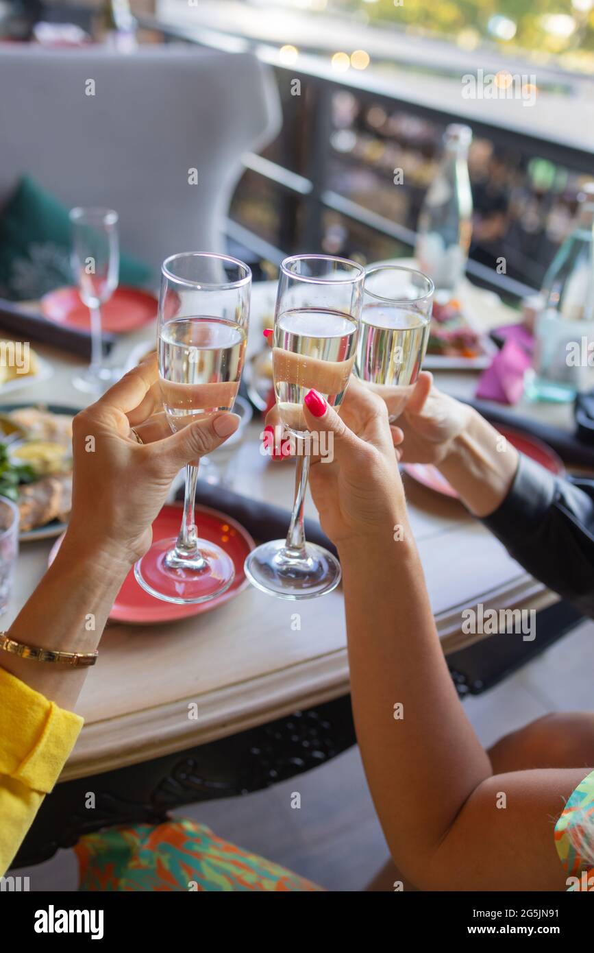 Clinking glasses with alcohol and toasting, party Stock Photo - Alamy