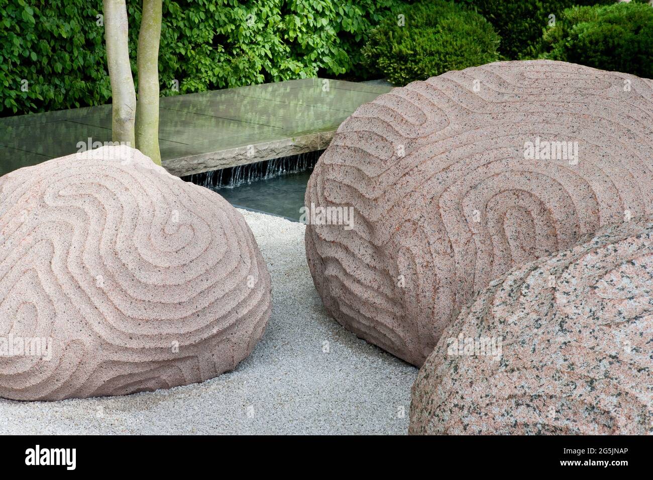 Japanese inspired garden with sculpted boulders and stone water feature ...