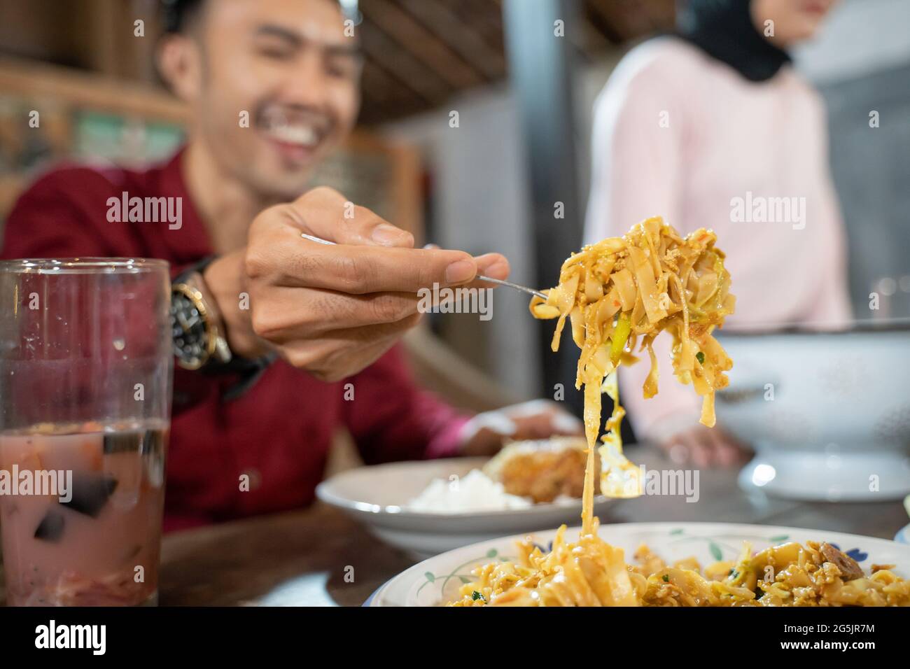 close up of a man's hand using a fork taking fried noodles Stock Photo ...