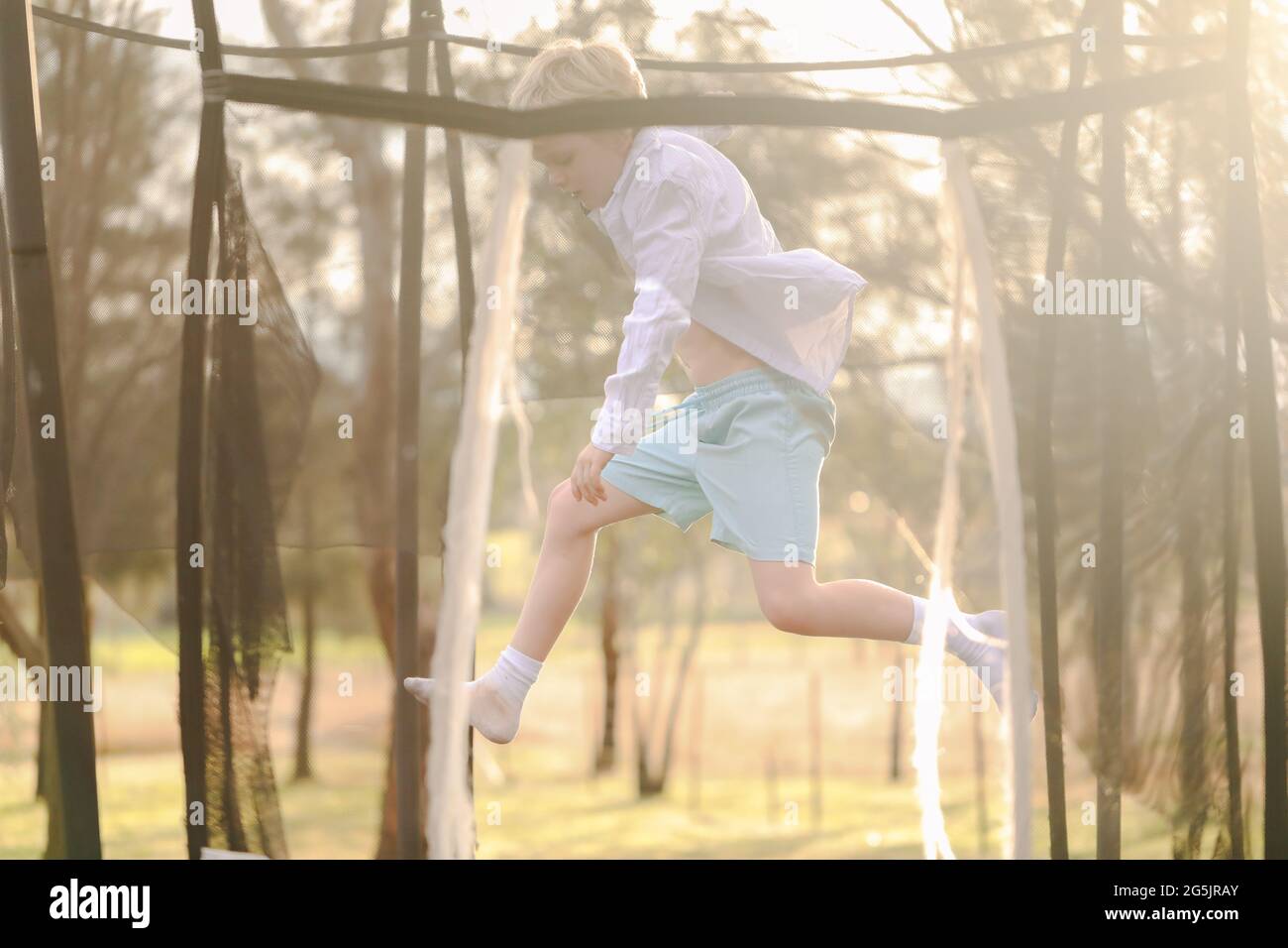 Little energetic boy is jumping high on a trampoline Stock Photo - Alamy