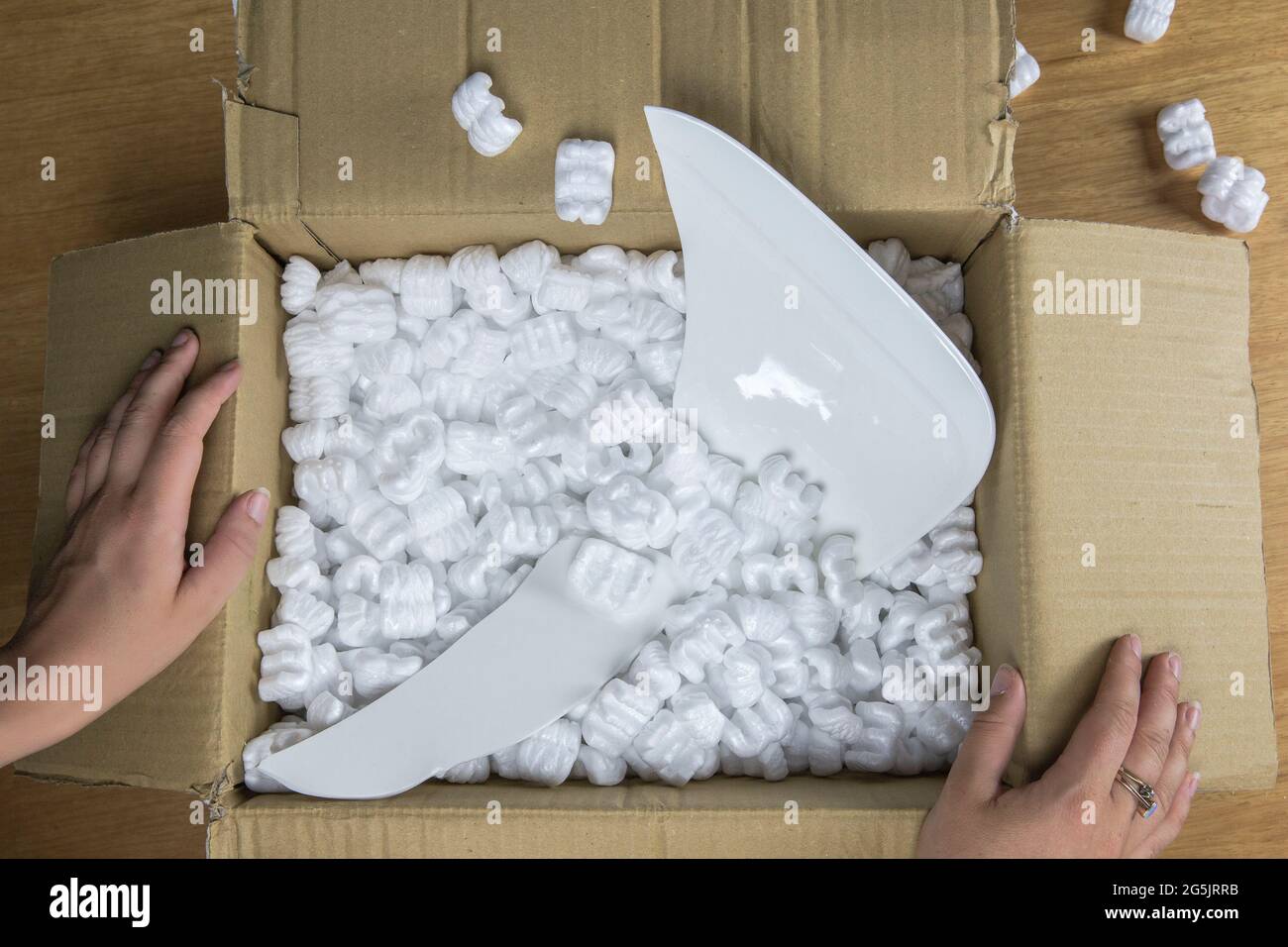 Broken plate in damaged cardboard box top view, damaged home delivery ...