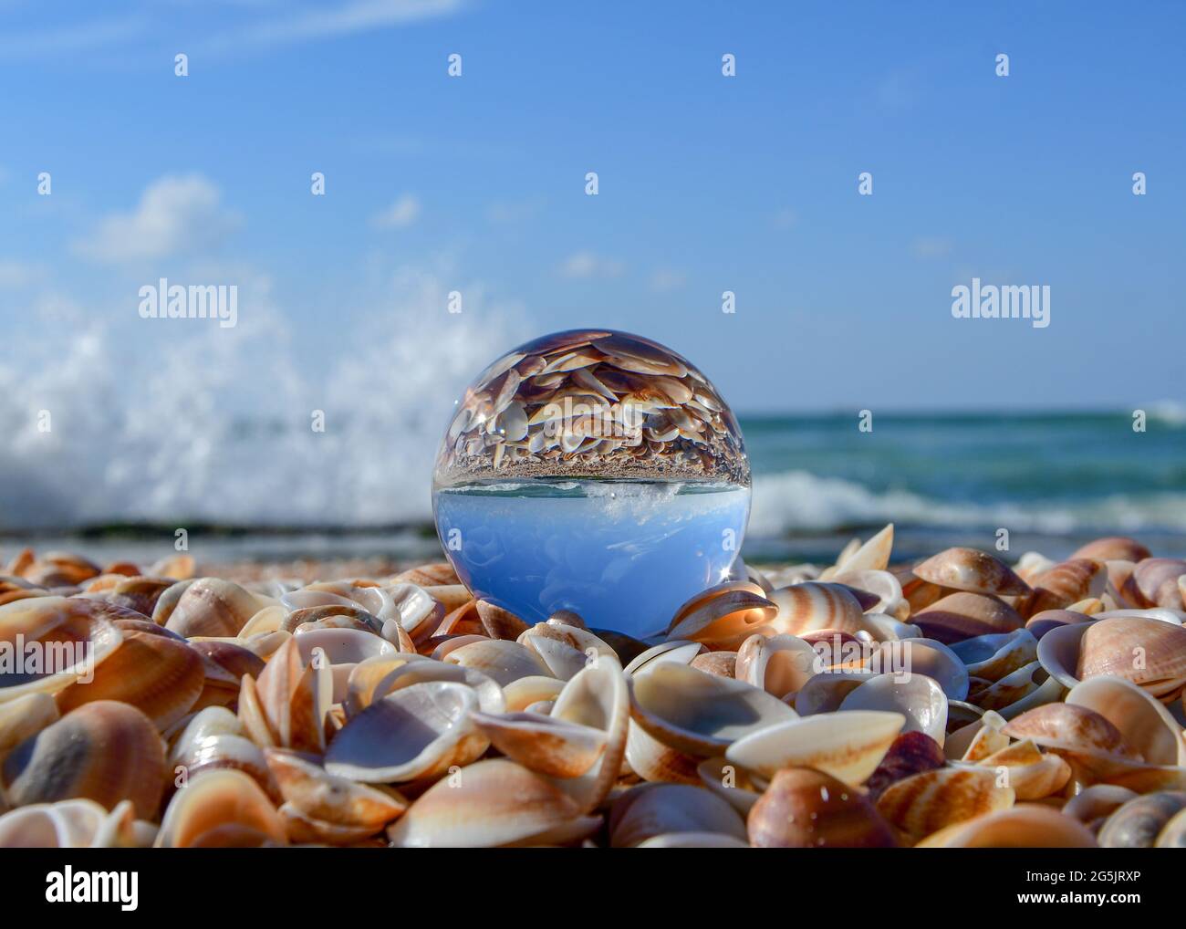 Crystal ball at a beach with the surroundings reflecting in the glass ...