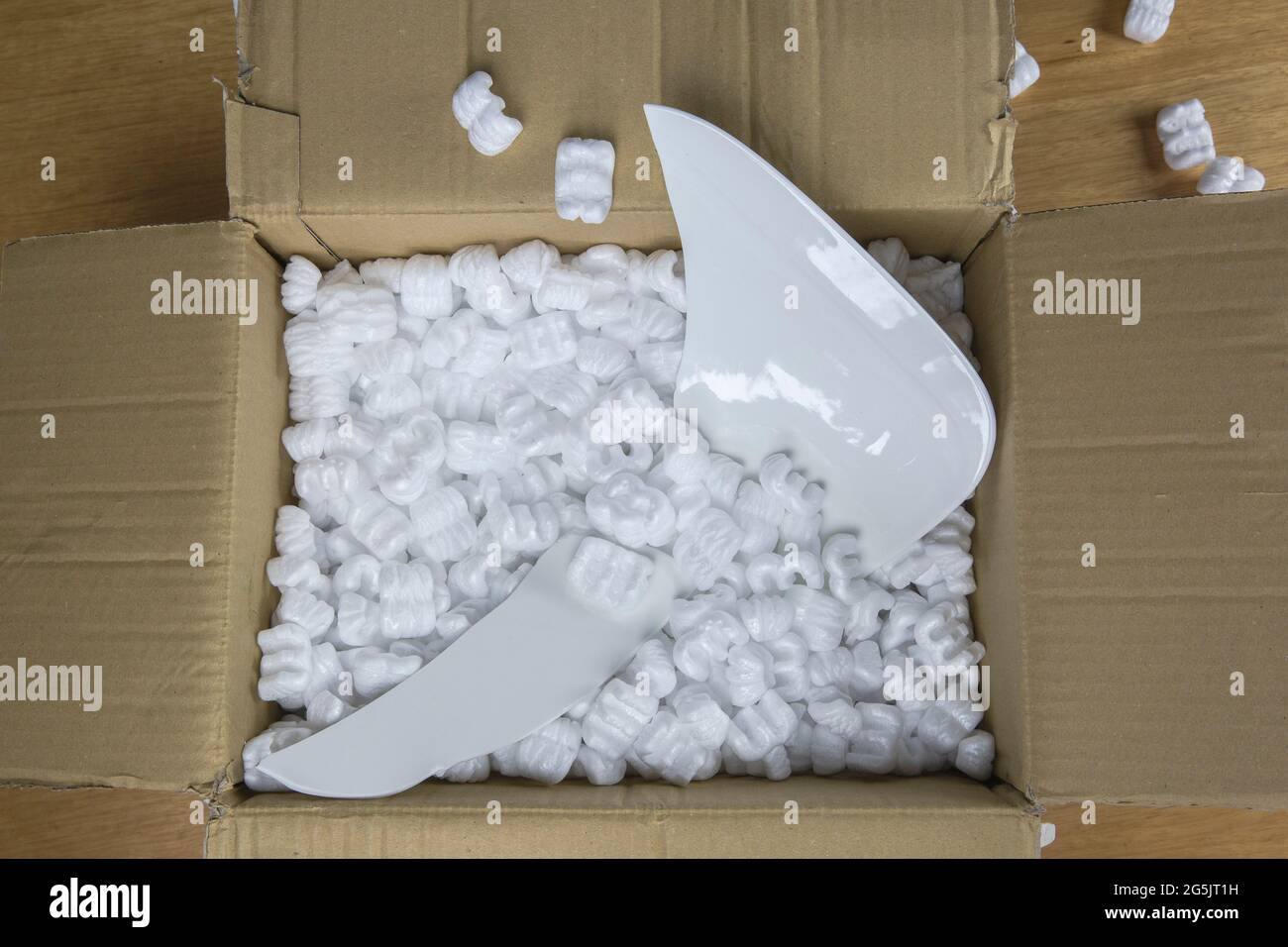 Broken plate in damaged cardboard box top view, damaged home delivery ...