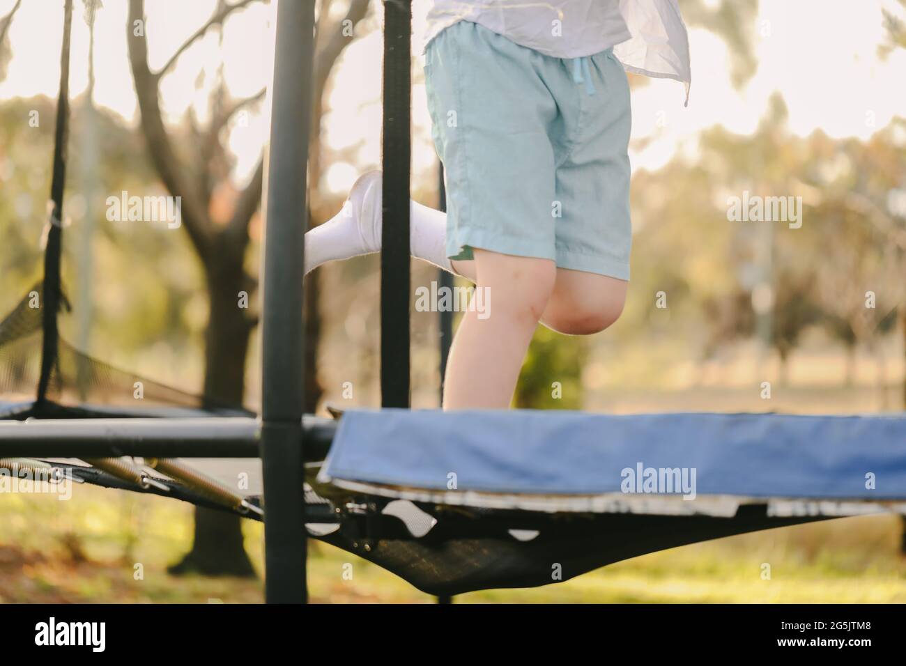 Little boy jumping high on a trampoline; a shot without a face Stock ...