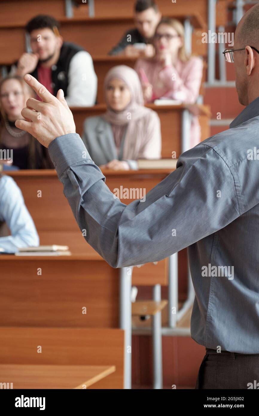 Teacher gesturing in front of group of students during explanation ...