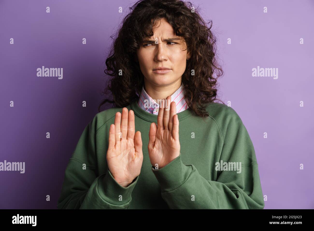 Angry confused woman gesturing stop sign over gray isolated background ...