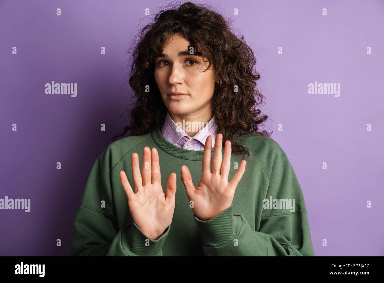 Angry confused woman gesturing stop sign over gray isolated background ...
