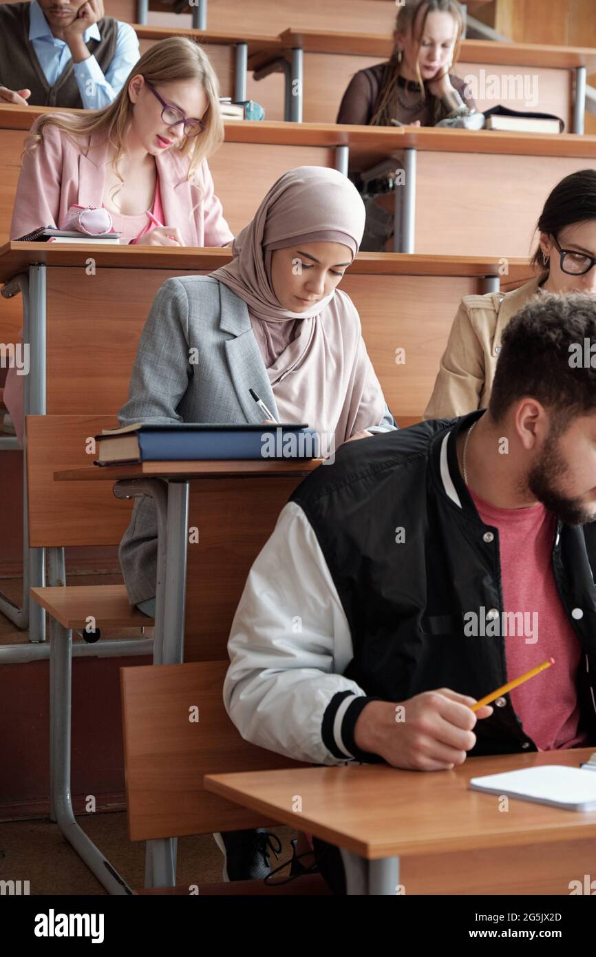 Students making notes while working individually in classroom Stock ...