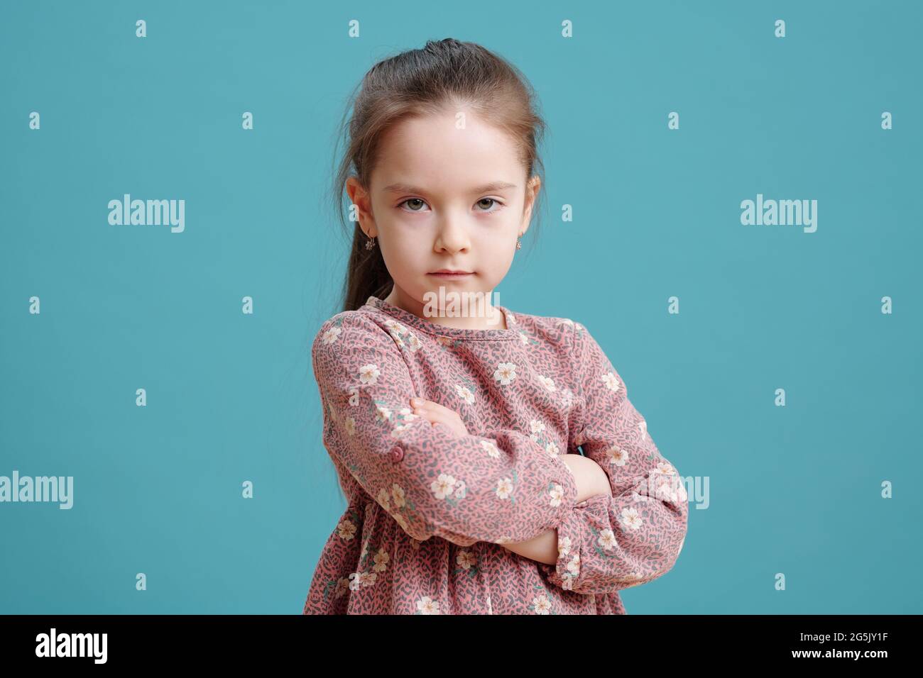 Cute Caucasian little girl looking at you seriously Stock Photo - Alamy