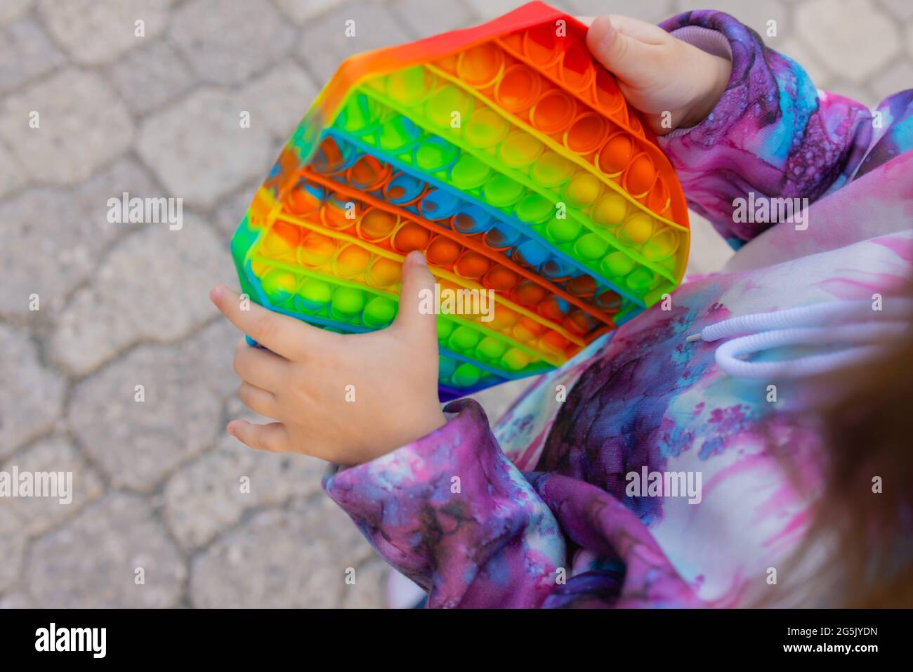 Pop it fidget toy in girl hand's. Colorful antistress kid's toy fidget ...