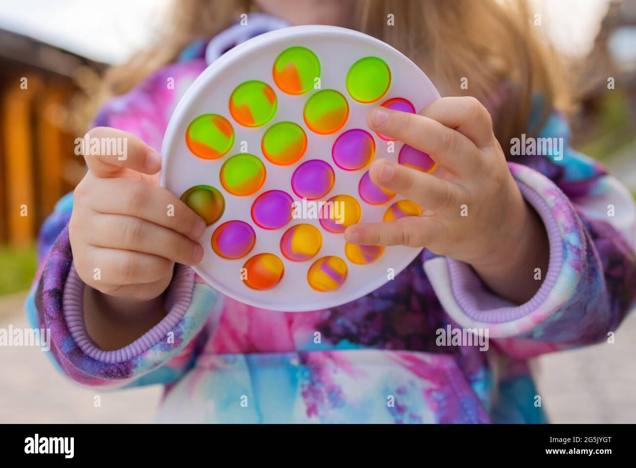 Pop it fidget toy in girl hand's. Colorful antistress kid's toy fidget ...
