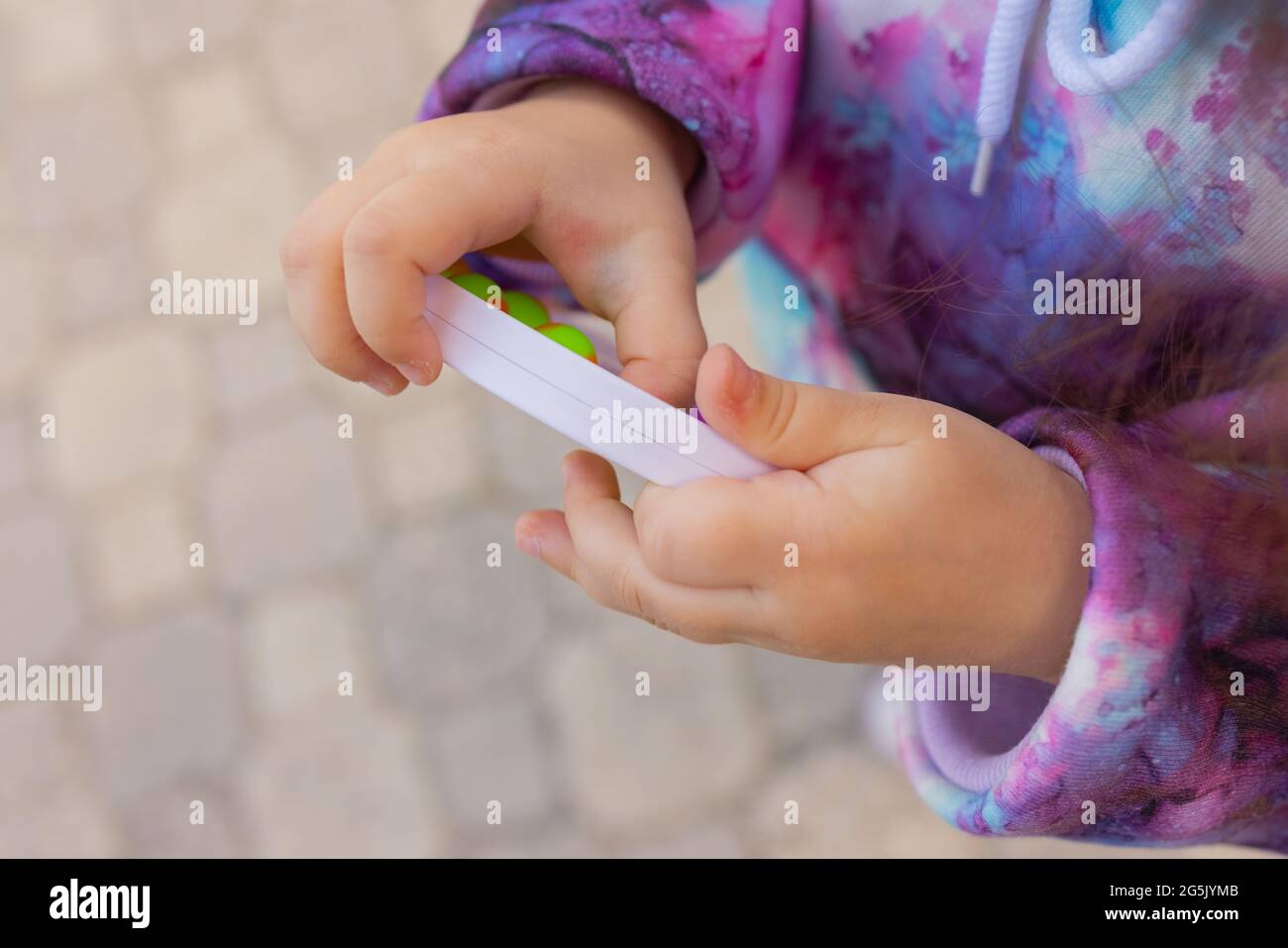 Pop it fidget toy in girl hand's. Colorful antistress kid's toy fidget ...