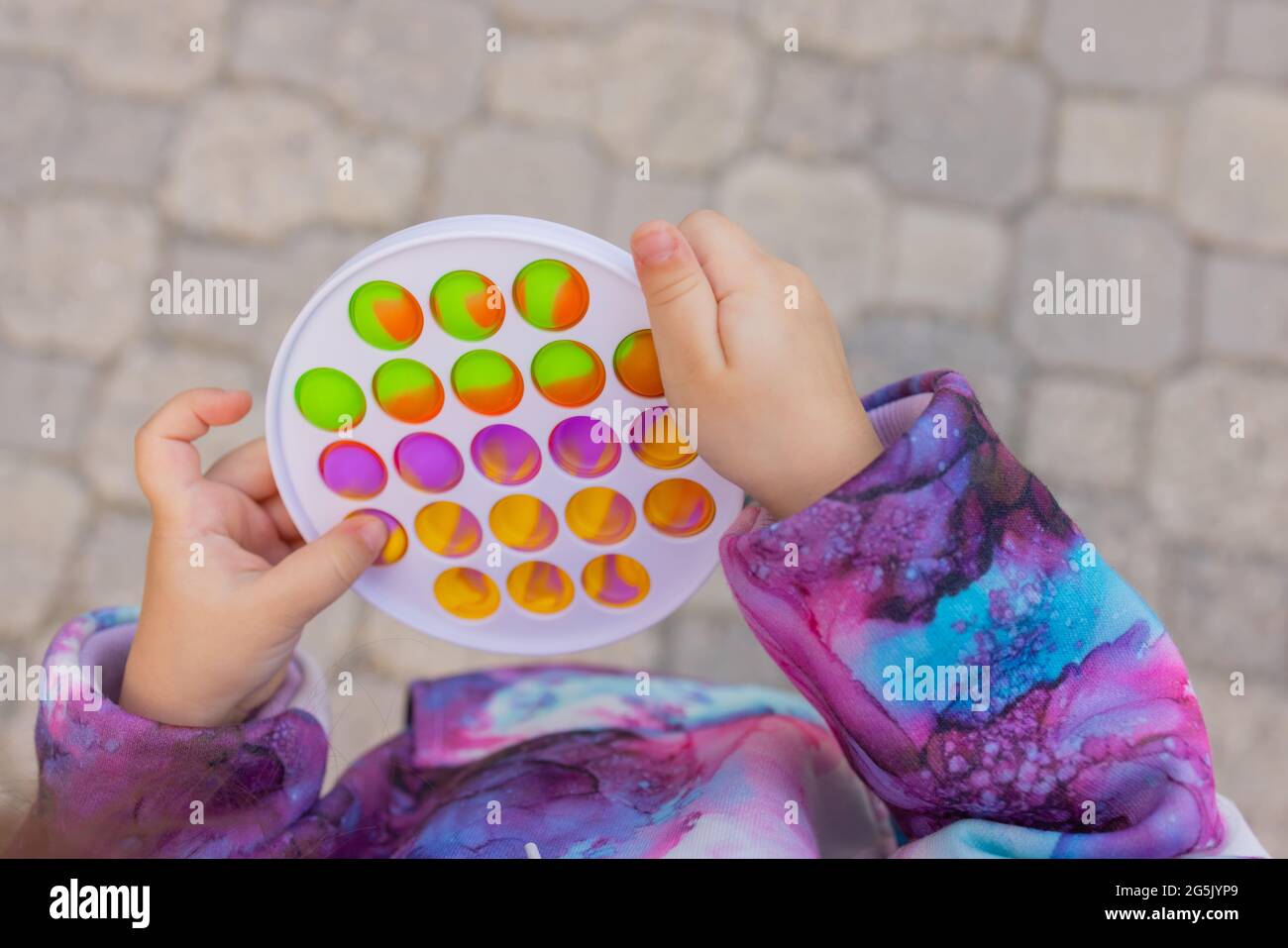 Pop it fidget toy in girl hand's. Colorful antistress kid's toy fidget ...