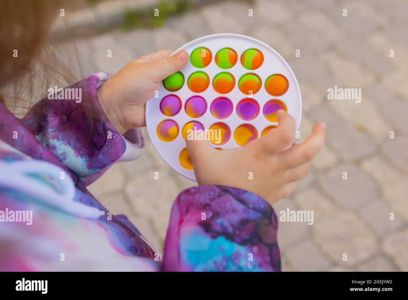 Pop it fidget toy in girl hand's. Colorful antistress kid's toy fidget ...