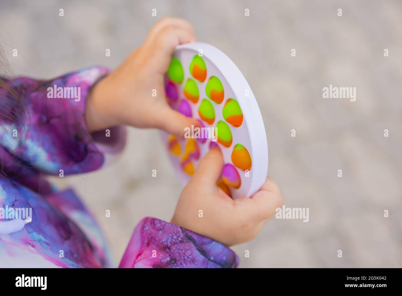 Pop it fidget toy in girl hand's. Colorful antistress kid's toy fidget ...