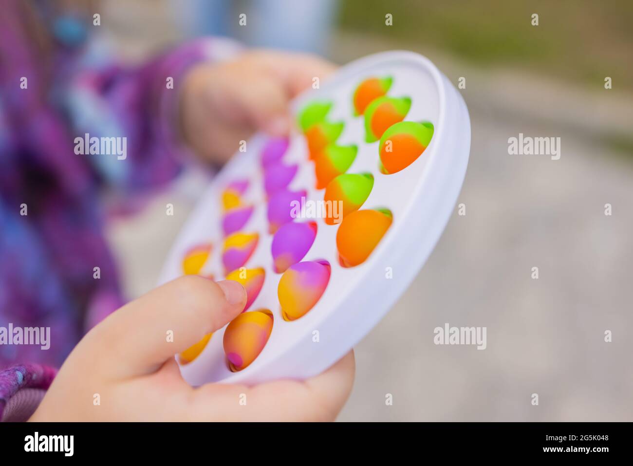 Pop it fidget toy in girl hand's. Colorful antistress kid's toy fidget ...