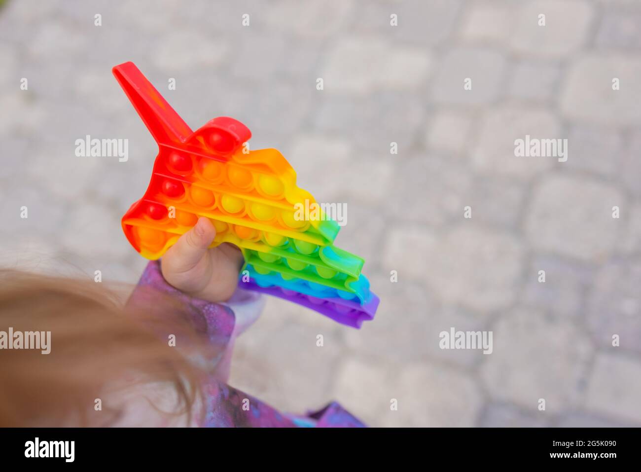 Pop it fidget toy in girl hand's. Colorful antistress kid's toy fidget ...