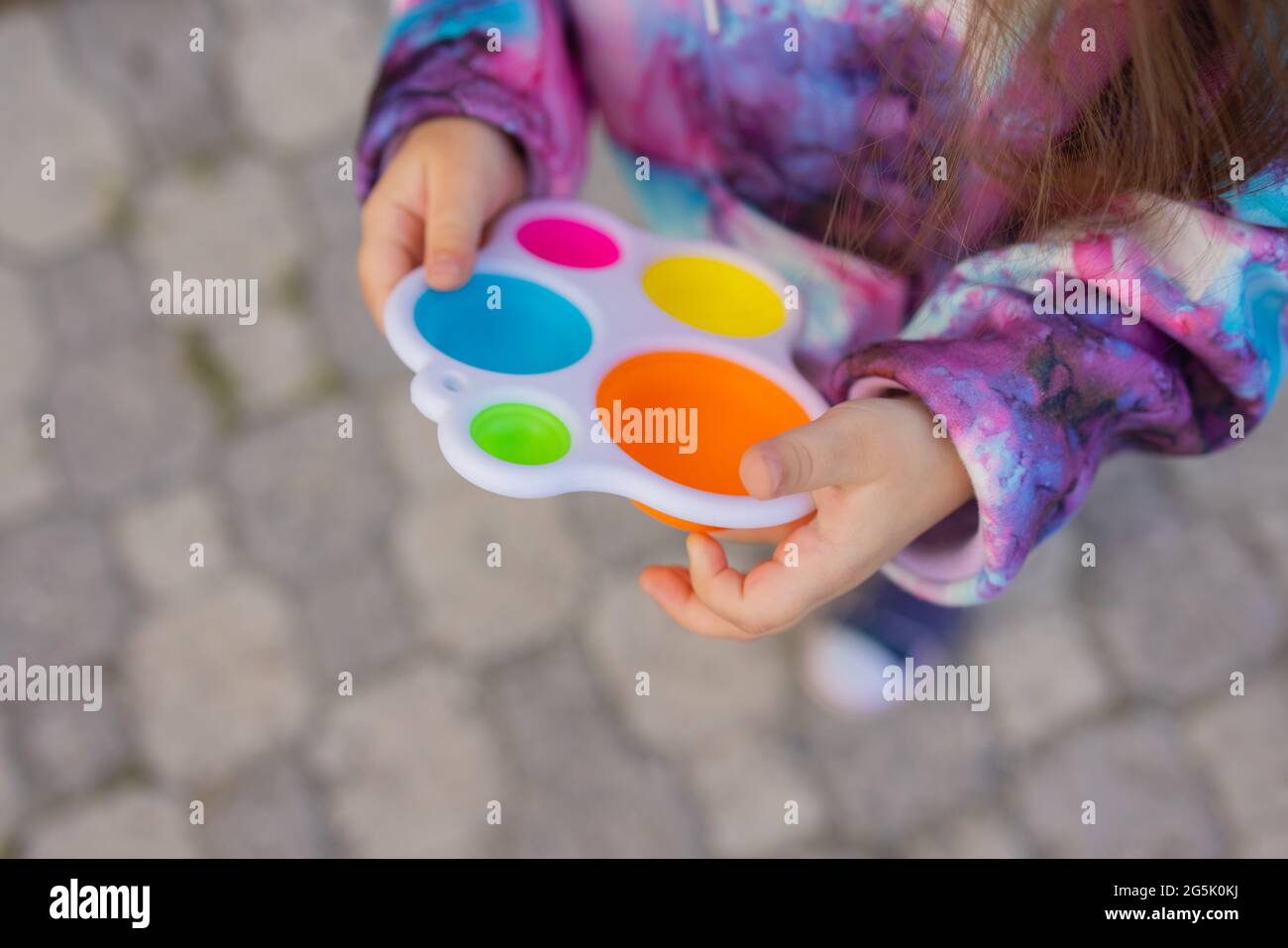 Pop it fidget toy in girl hand's. Colorful antistress kid's toy fidget ...