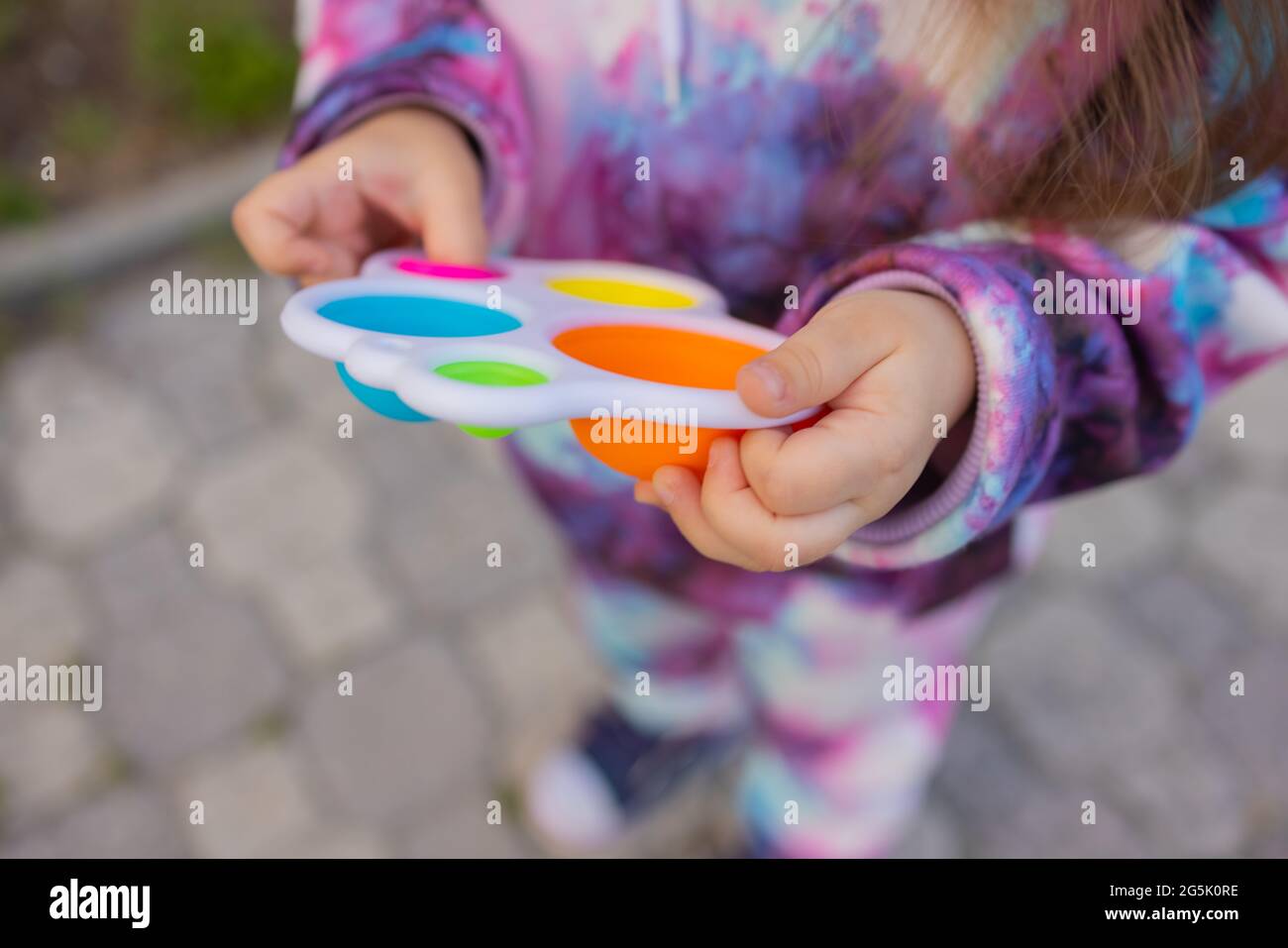 Pop it fidget toy in girl hand's. Colorful antistress kid's toy fidget ...