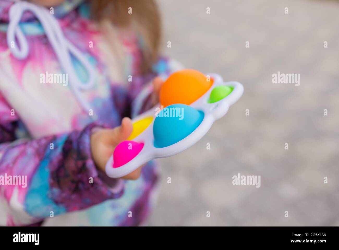 Pop it fidget toy in girl hand's. Colorful antistress kid's toy fidget ...