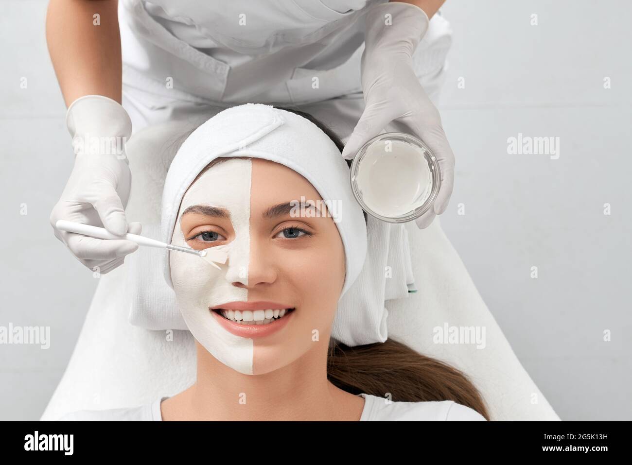 Top view portrait of attractive smiling young woman on cleaning face in ...