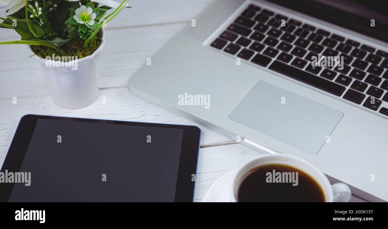 Laptop computer, plant, tablet and coffee on white desk Stock Photo - Alamy
