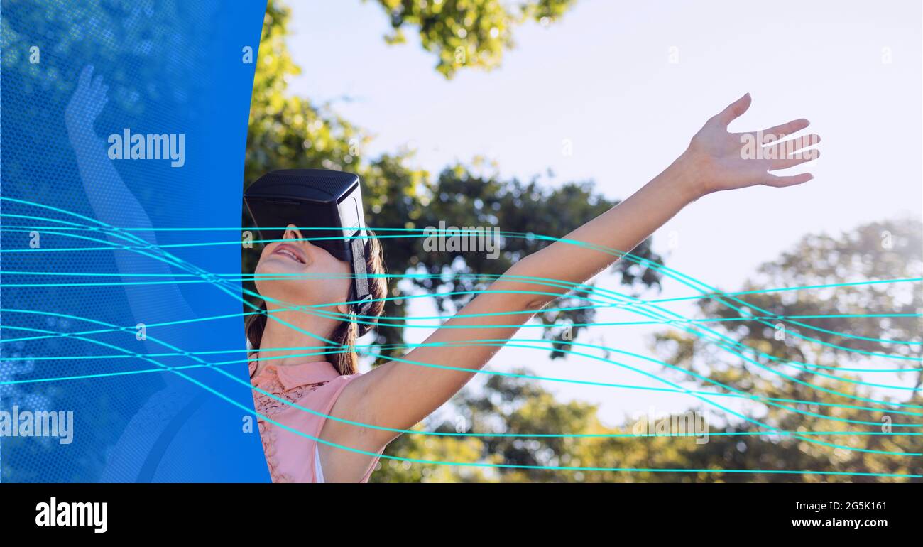 Composition of blue light trails over woman wearing vr headset Stock ...