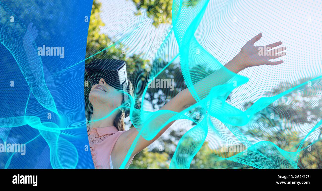Composition of blue light trails over woman wearing vr headset Stock ...