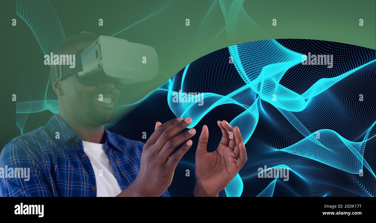 Composition of blue light trails and man wearing vr headset touching ...