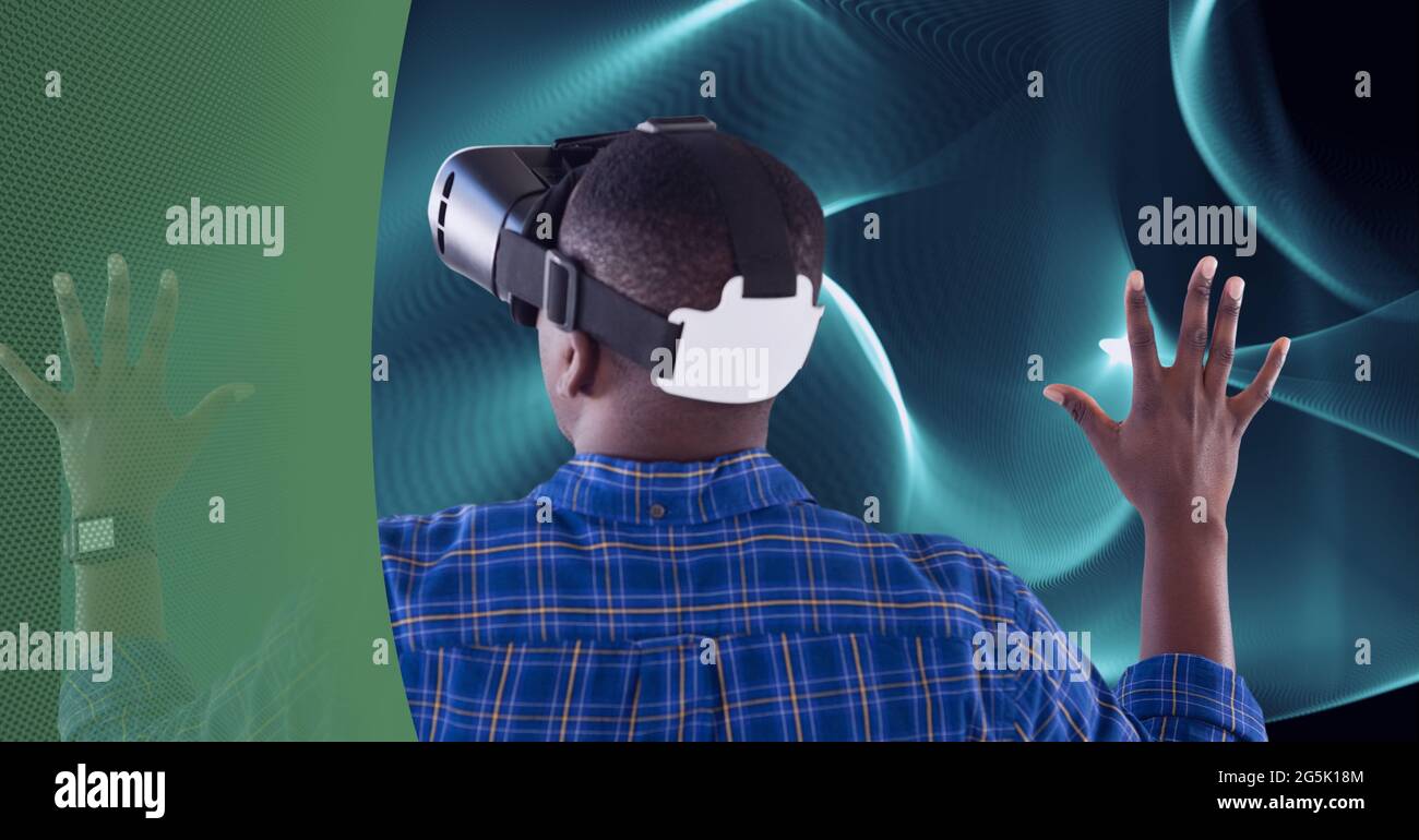 Composition of blue light trails and man wearing vr headset touching ...