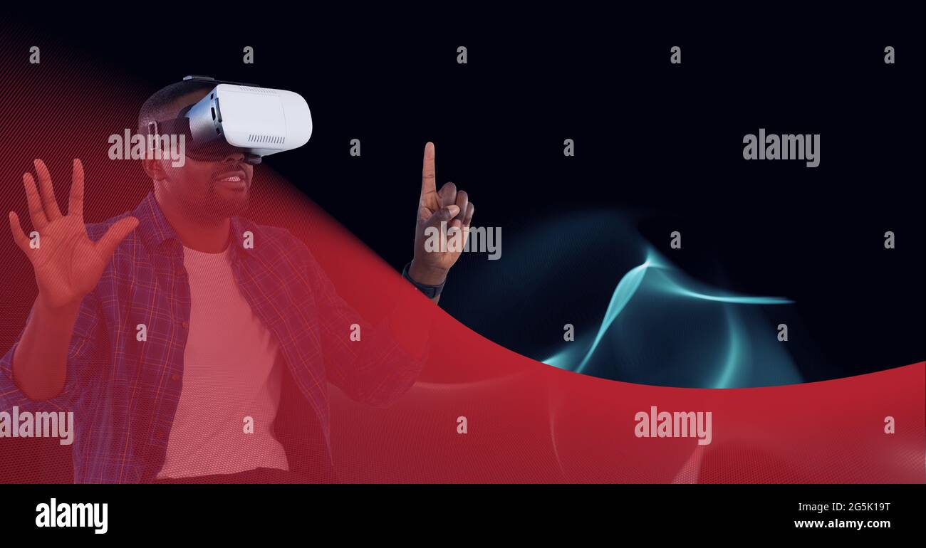 Composition of blue light trails and man wearing vr headset touching ...