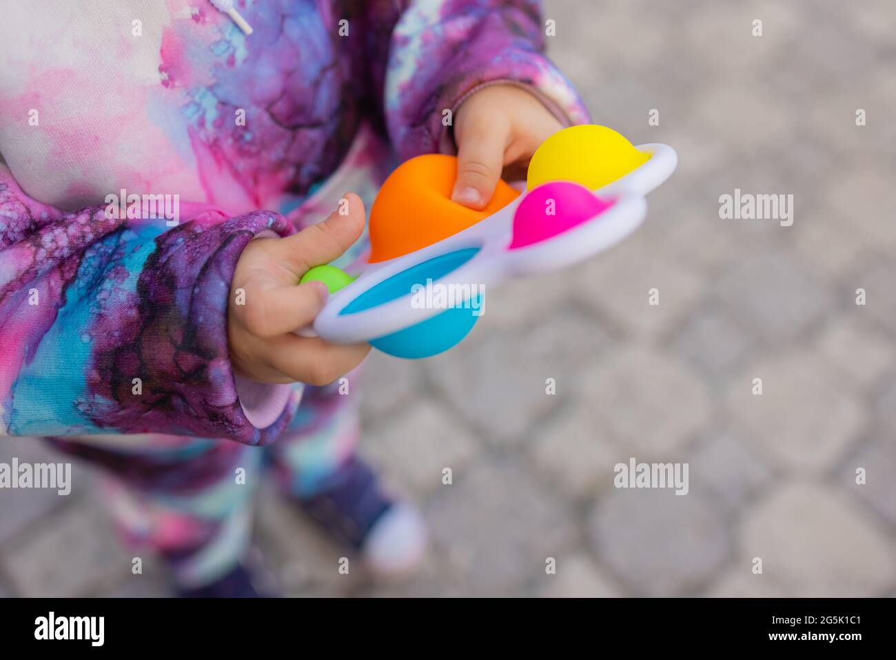 Pop it fidget toy in girl hand's. Colorful antistress kid's toy fidget ...