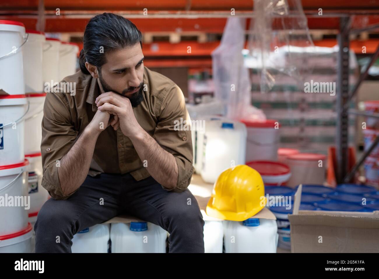 Young tired male worker of warehouse having rest Stock Photo - Alamy