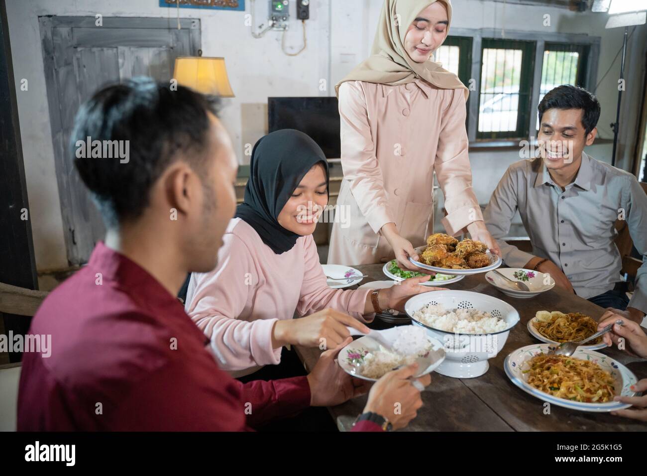 group of friends having lunch together while gathering with friends ...