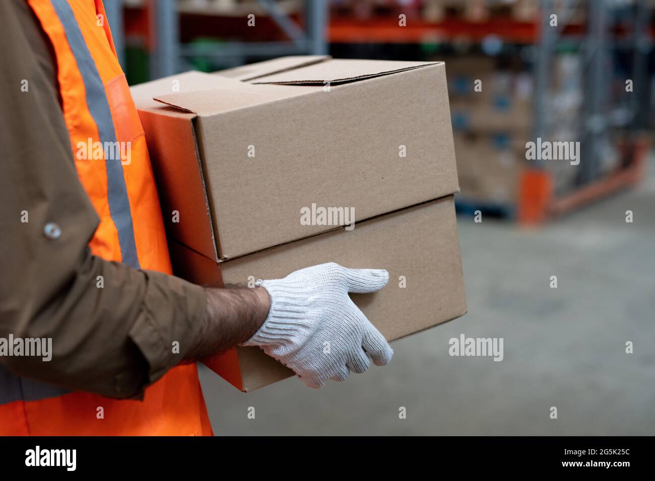 Gloved loader carrying two cardboard boxes with goods for delivery ...