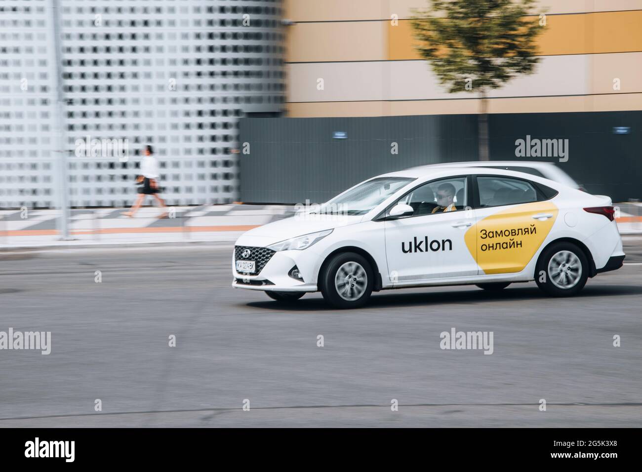Ukraine, Kyiv - 27 June 2021: White Taxi Uklon car moving on the street ...
