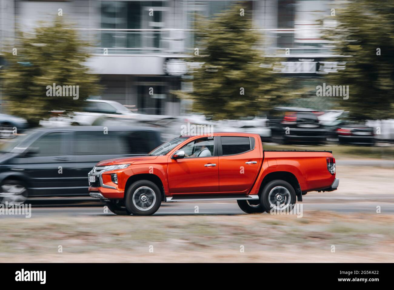 Ukraine, Kyiv - 27 June 2021: Orange Mitsubishi Triton car moving on ...