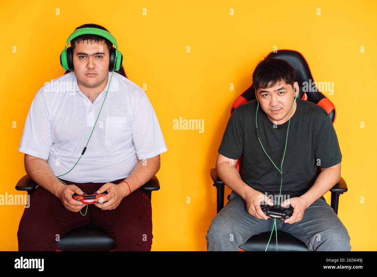 Two guys playing video games in front of yellow background Stock Photo ...