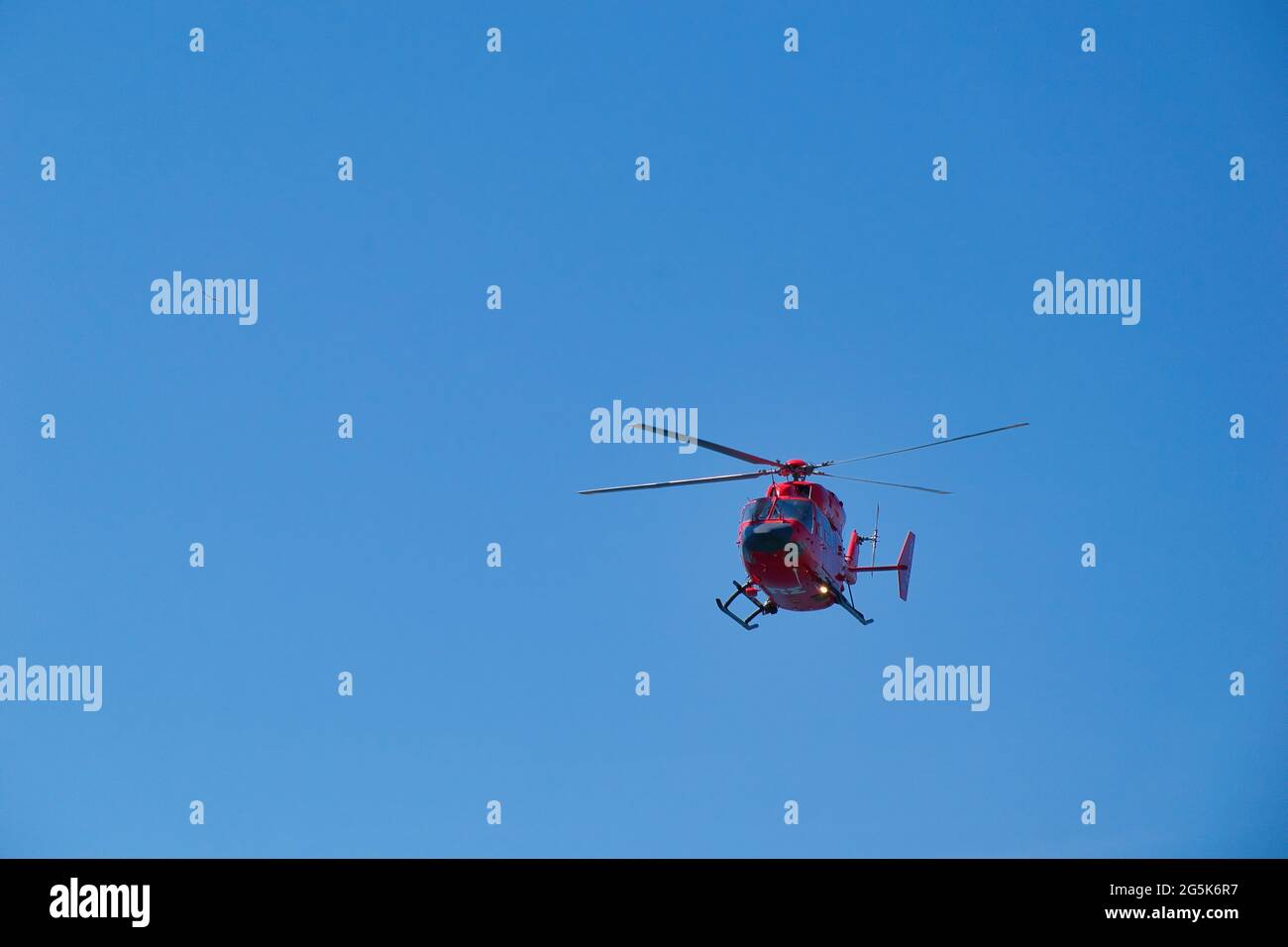 Small red helicopter in low flight Stock Photo - Alamy