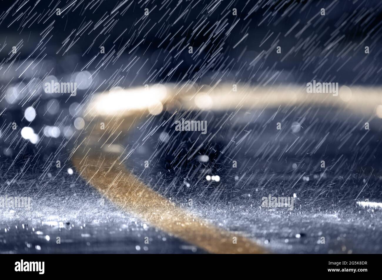 Heavy rain or downpour, raindrops fall on the asphalt, night or evening ...