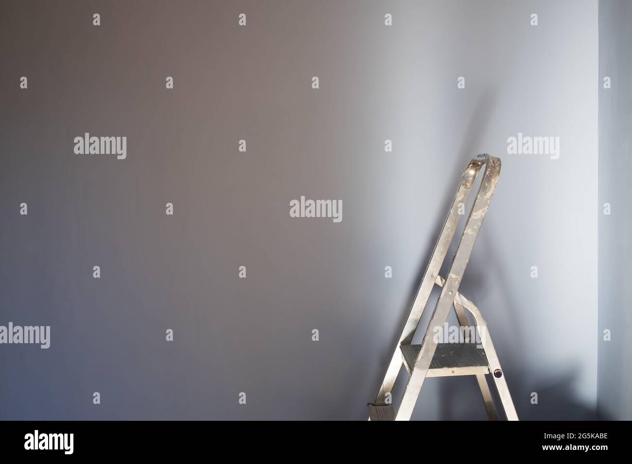 Home improvement with ladder and white wall Stock Photo - Alamy