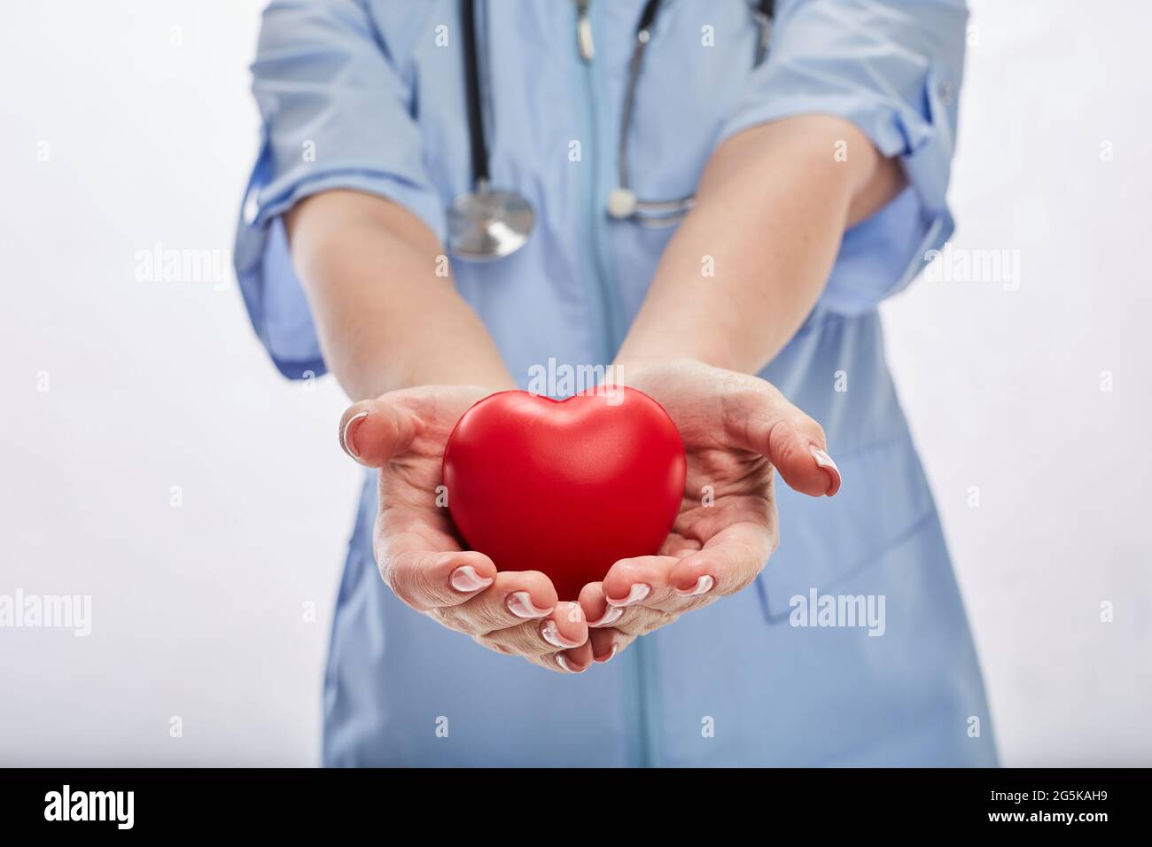 Close up of female doctor hands holding the heart. Red heart showing by ...