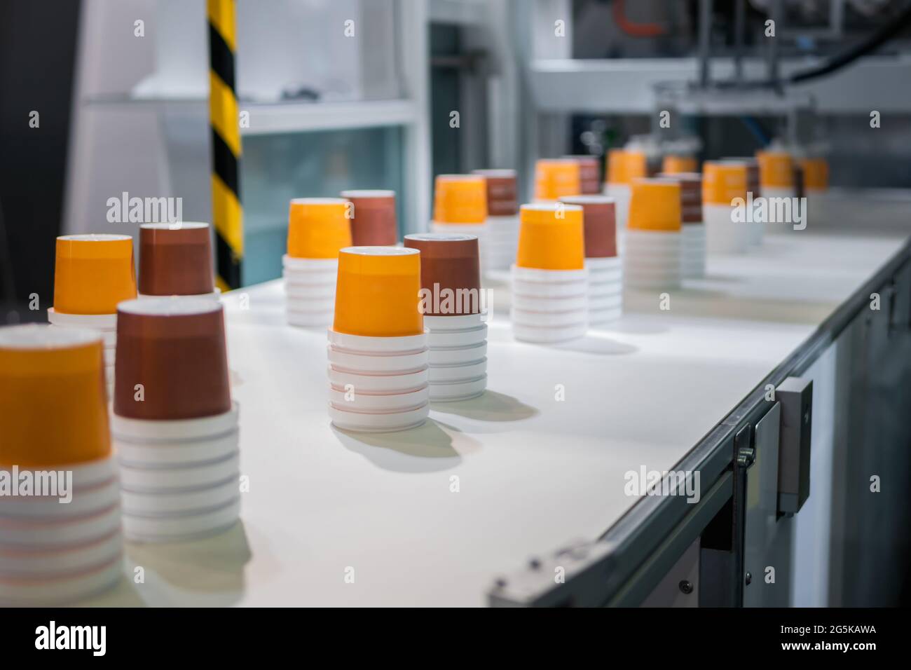 Empty plastic cups moving on conveyor belt at package exhibition Stock ...