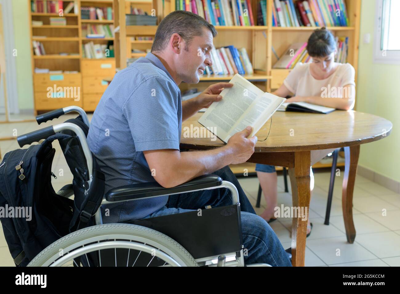 man in wheelchair in the library Stock Photo - Alamy