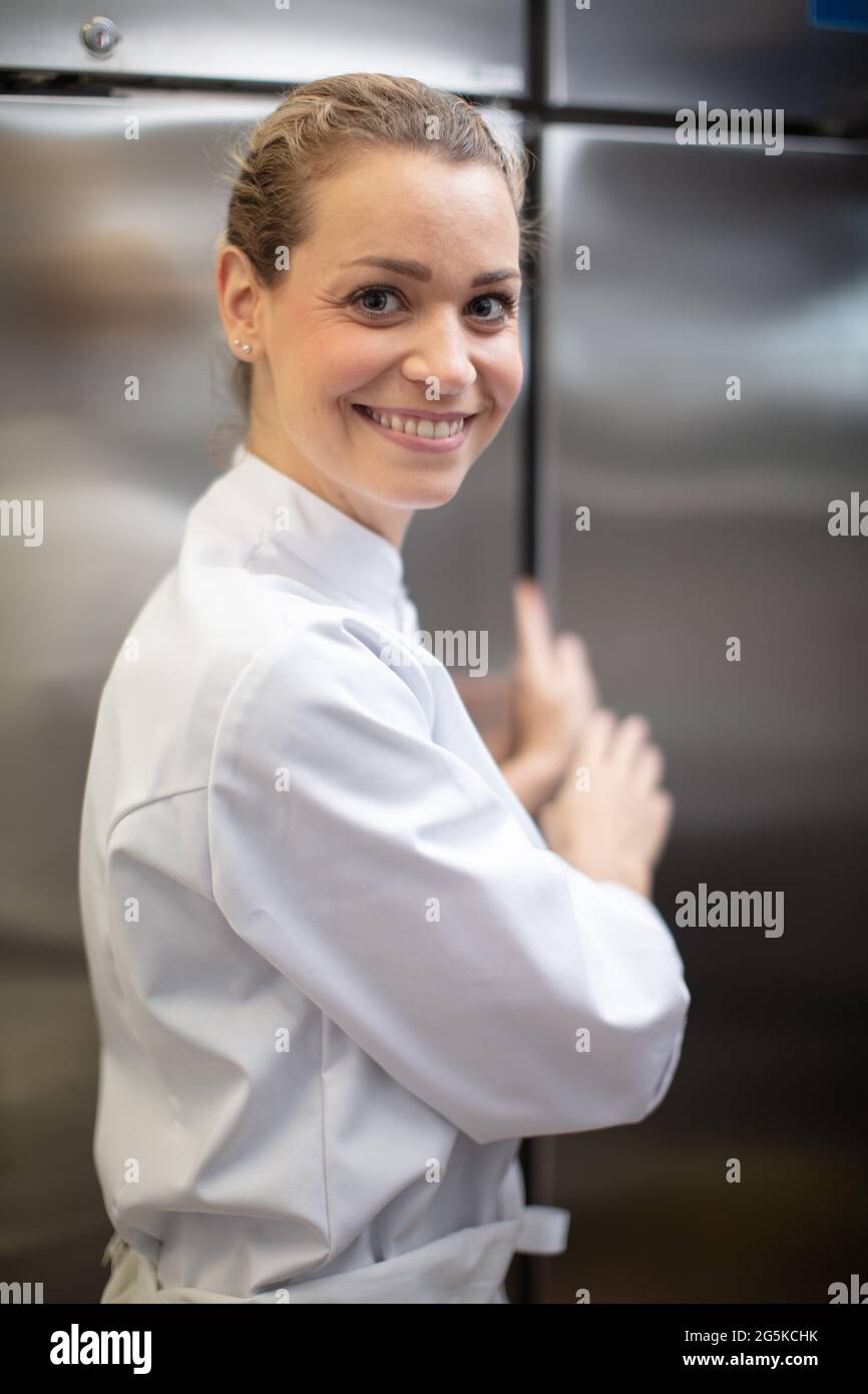 female chef stood by stainless-steel industrial fridge Stock Photo - Alamy